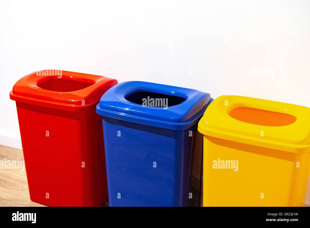 Three plastic trash bins against the wall in the building Stock Photo ...