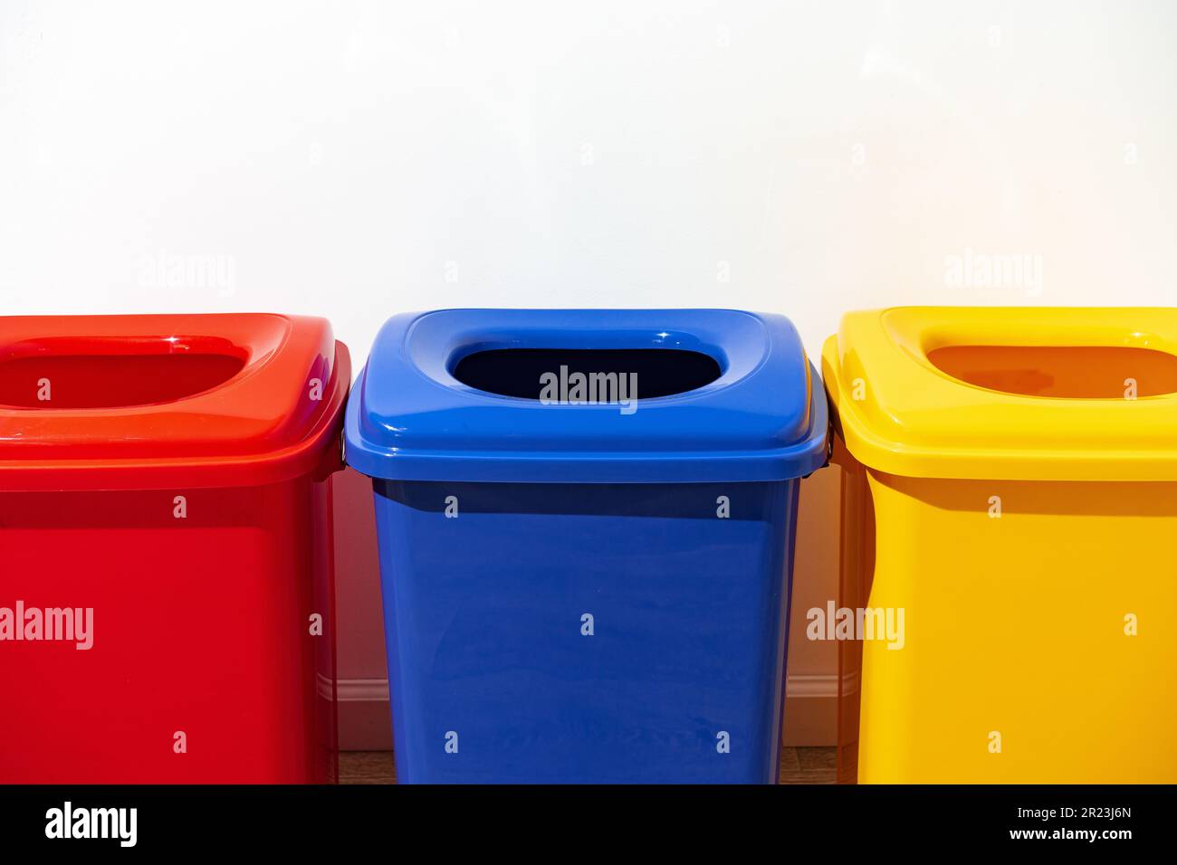 Three plastic trash bins against the wall in the building Stock Photo ...