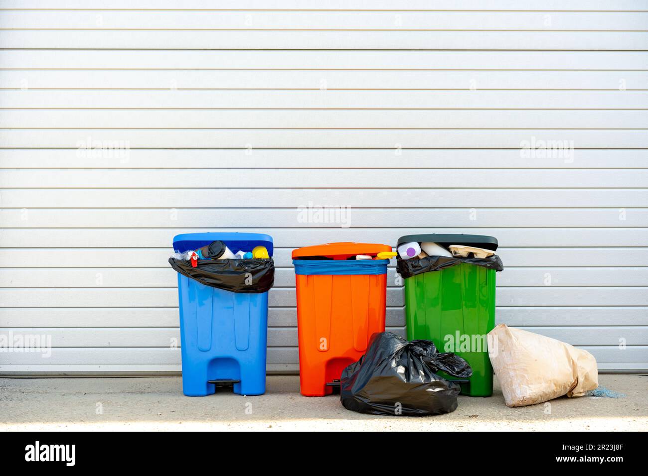 Three trash containers full of garbage near the building Stock Photo ...