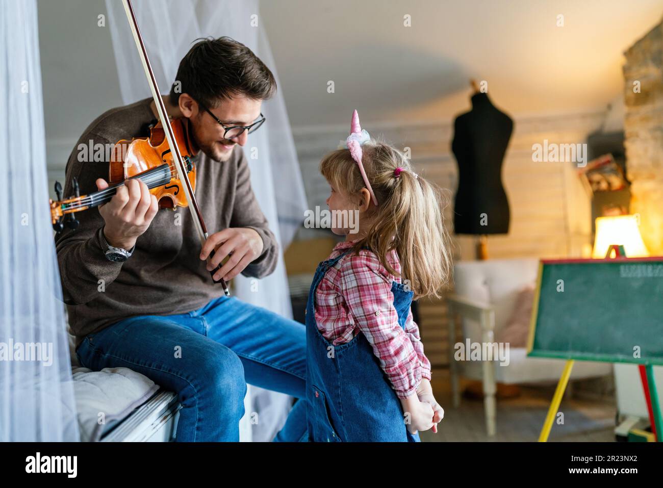 Happy family. Father and daughter playing on instrument together. Adult ...