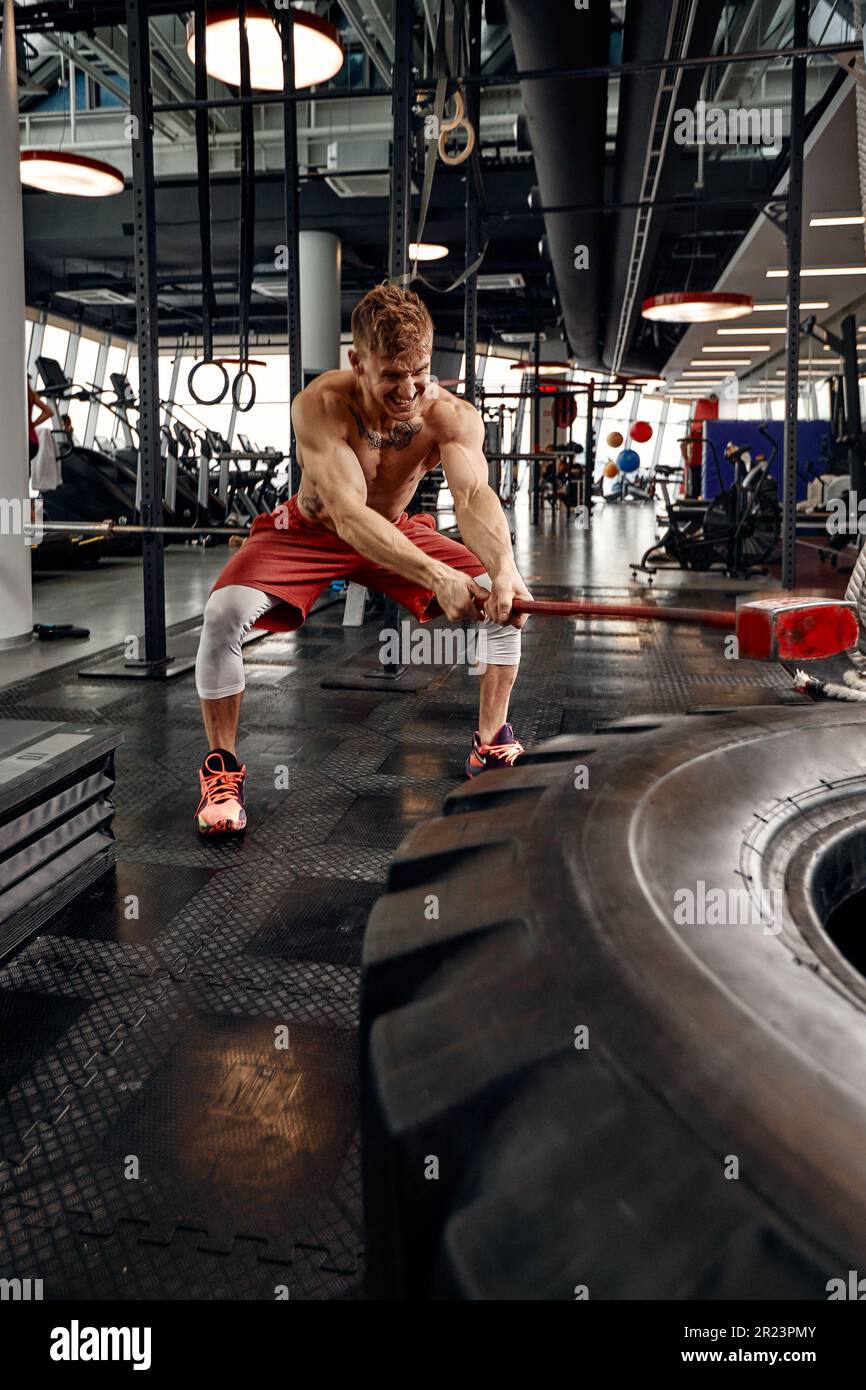 Strength concept. Male athlete using hammer during fitness workout ...