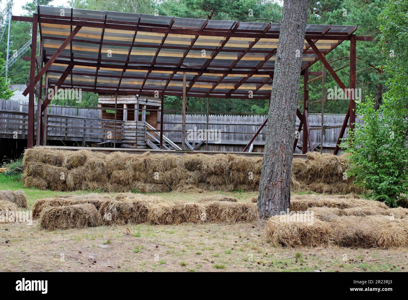 Straw bales under a wooden roof in the courtyard of a country house ...