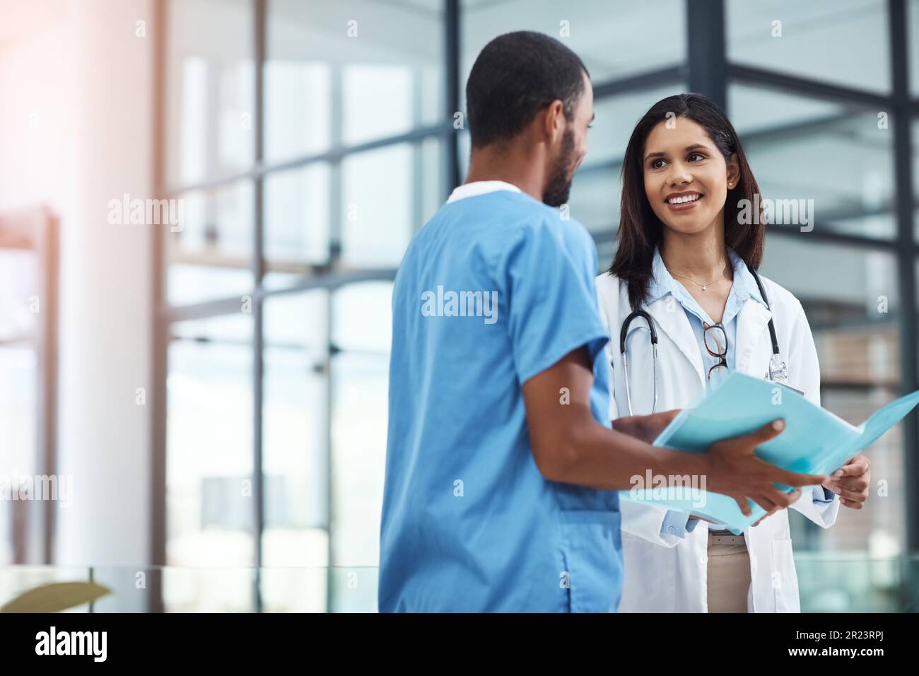 Life saving experts. two young doctors discussing the contents of a ...