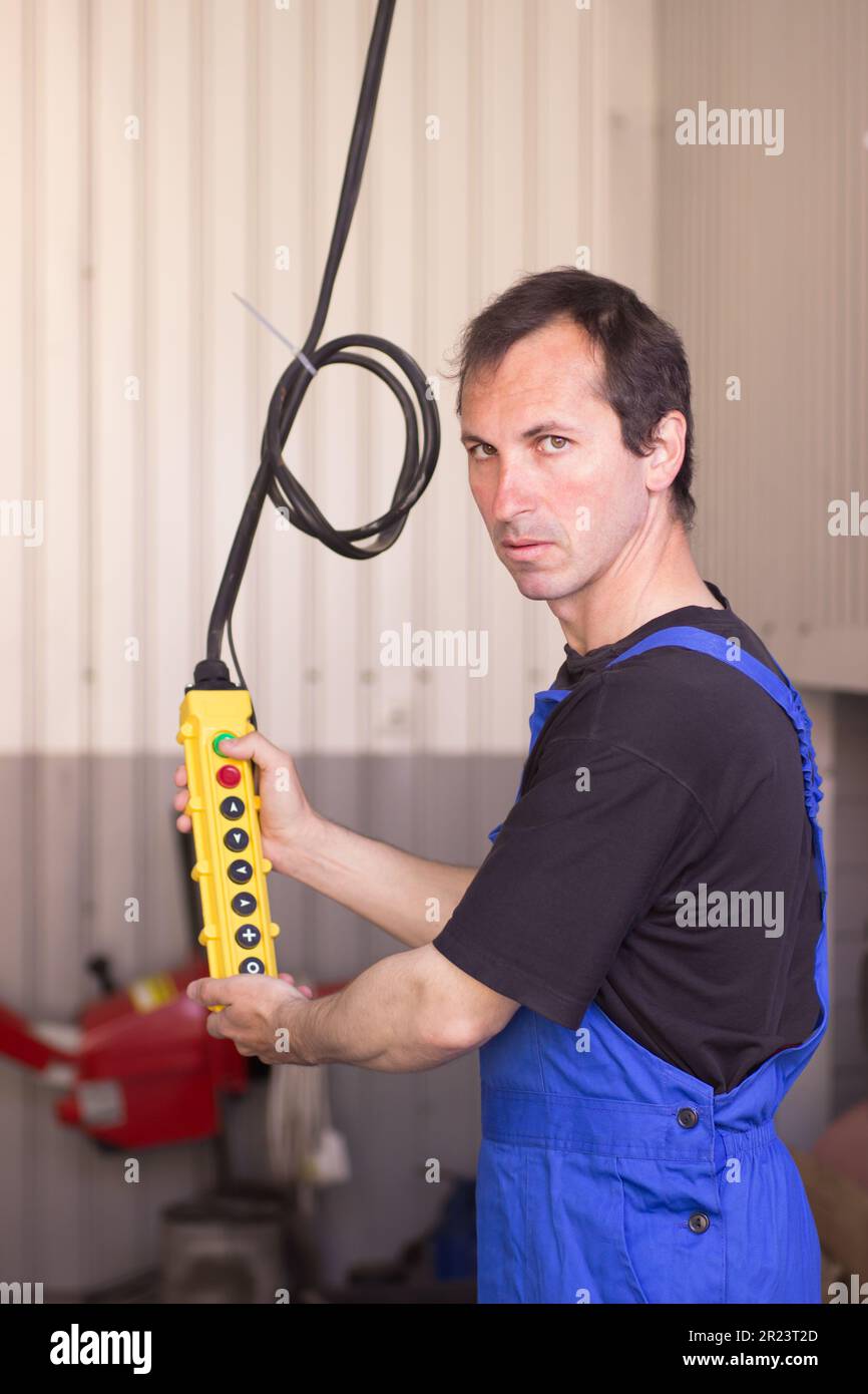 Adult man holding lift control panel Stock Photo - Alamy