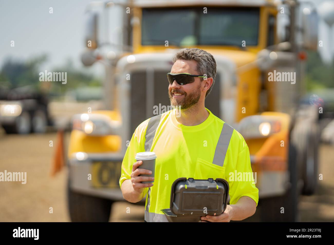 Men driver near lorry truck. Man truck driver in safety vest near truck ...