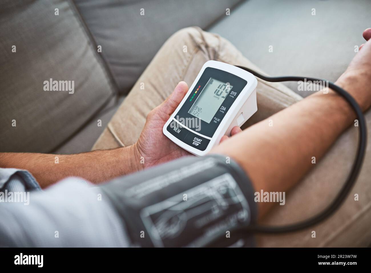 Hypertension, machine and person test blood pressure in a home sofa or ...