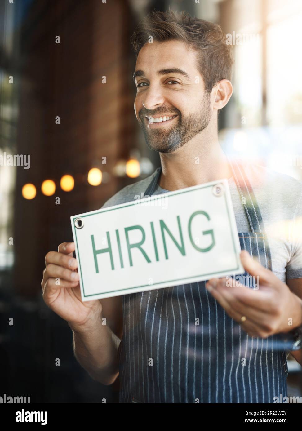 Man with hiring sign, window with job opportunity advertising, happy ...