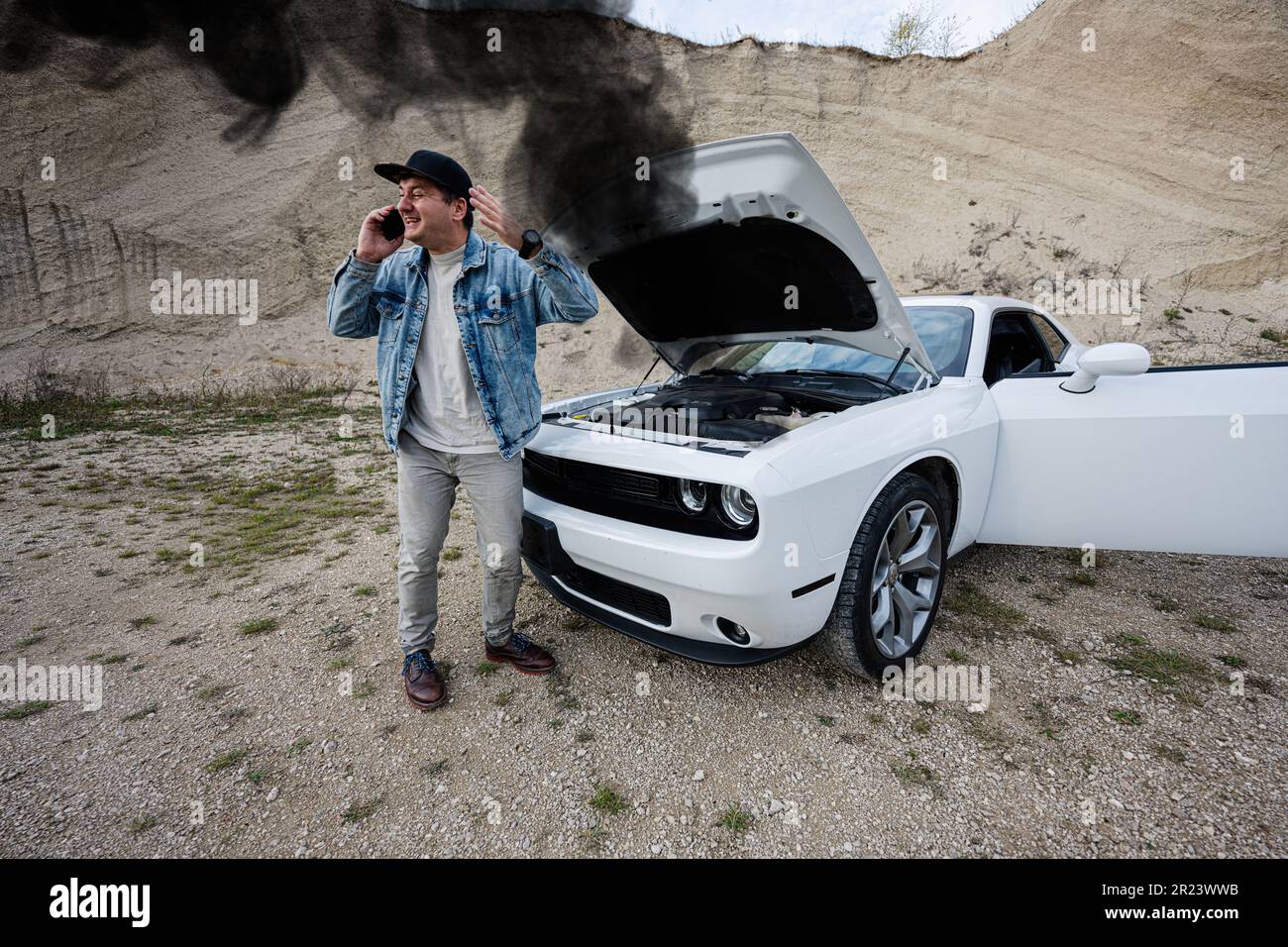 Shocked man calling on phoen to emergency near his broken muscle car ...