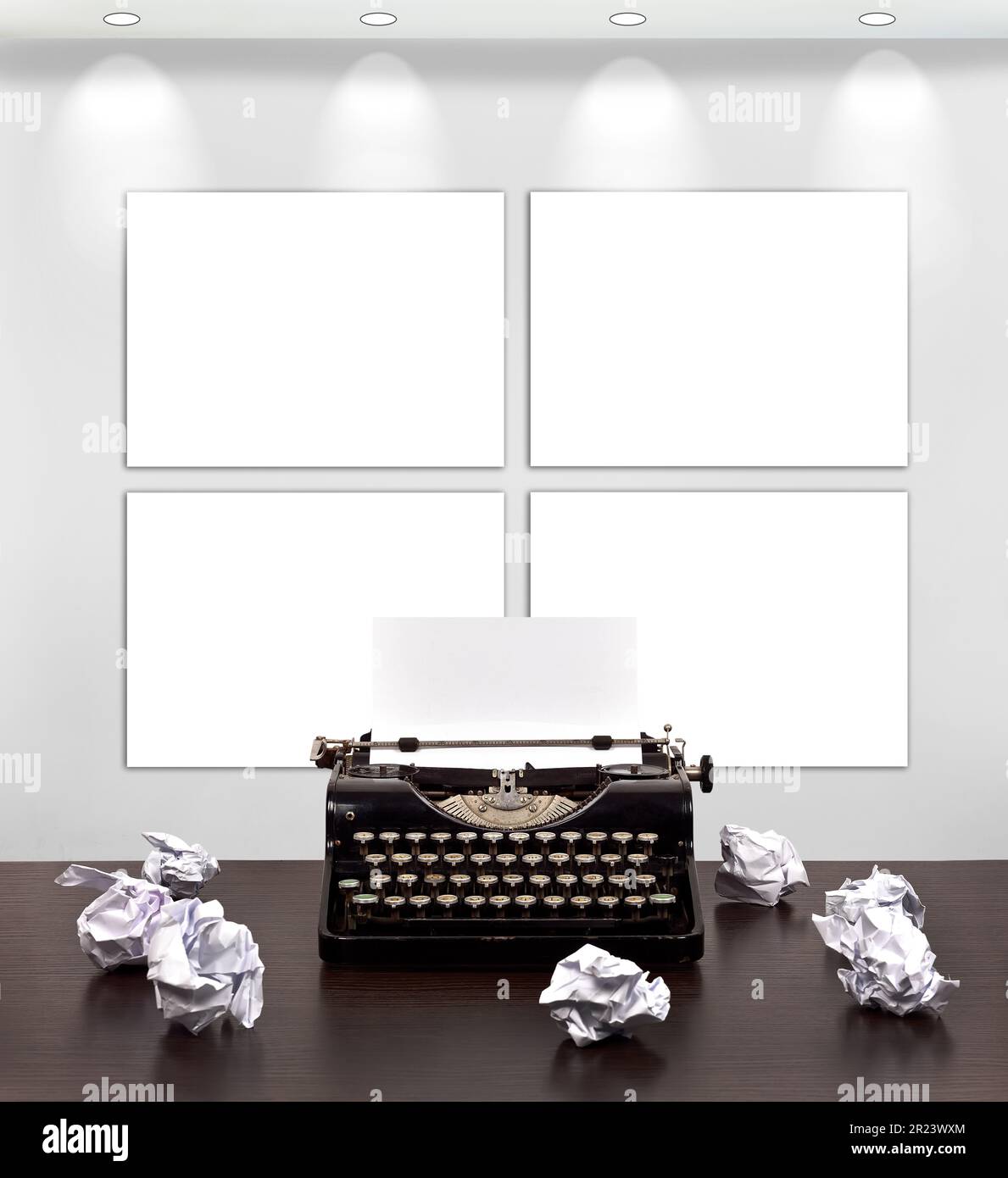 Typewriter with paper and four blank placards on concrete wall ...