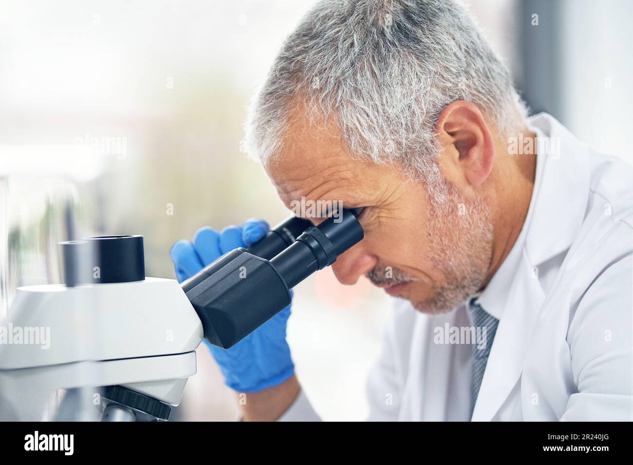 Microscope, science and face of man in laboratory for research, medical ...