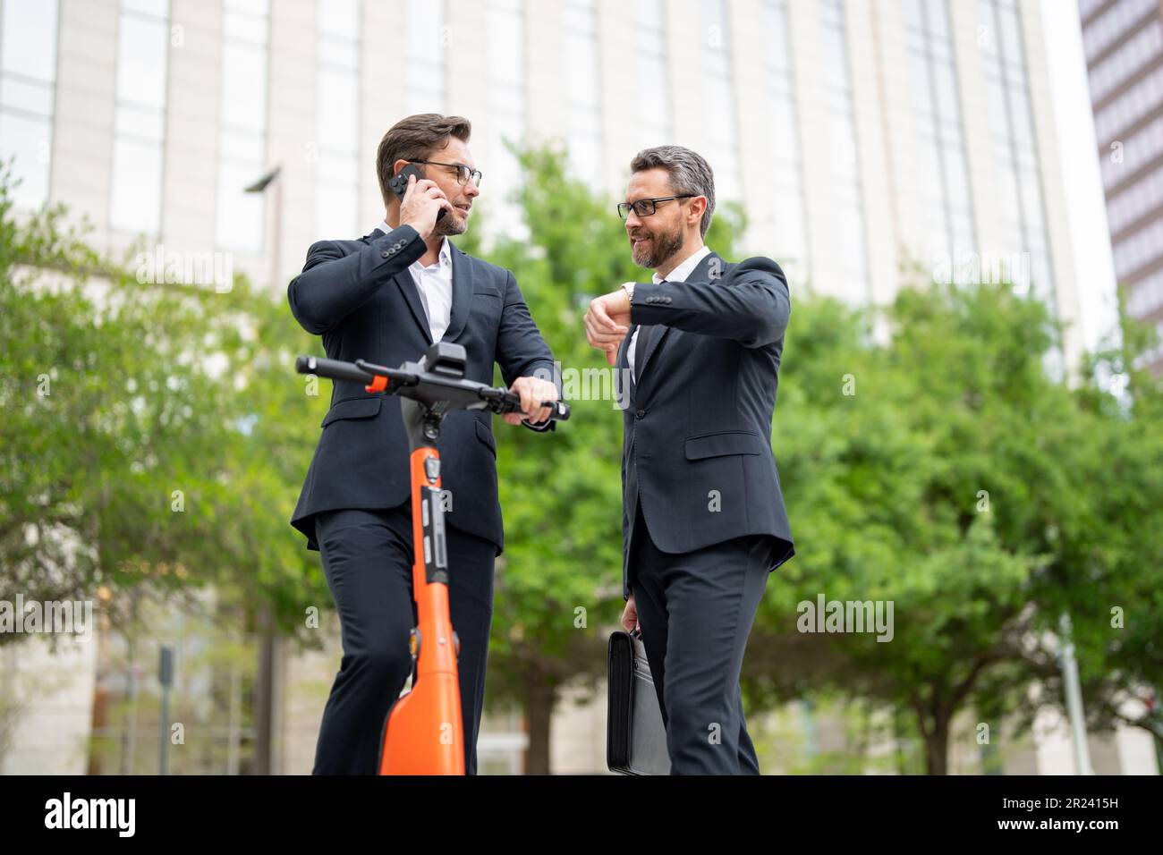 Caucasian employee on urban background office building texting messages ...