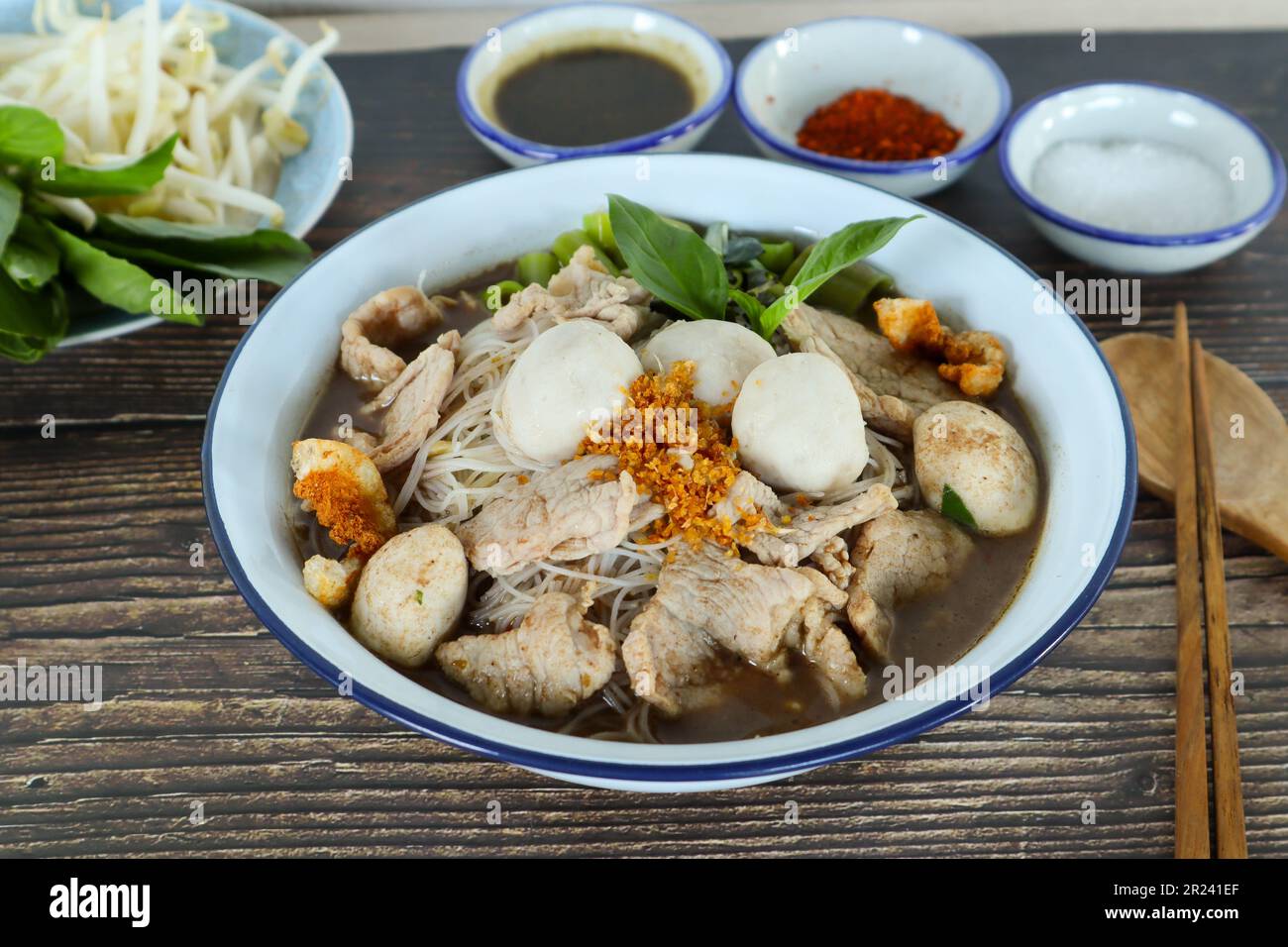 Thai style noodle soup served with vegetable flat lay on wood table ...