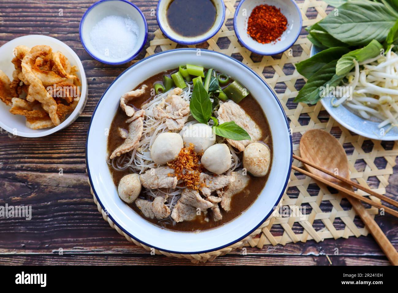Thai style noodle soup served with vegetable flat lay on wood table ...