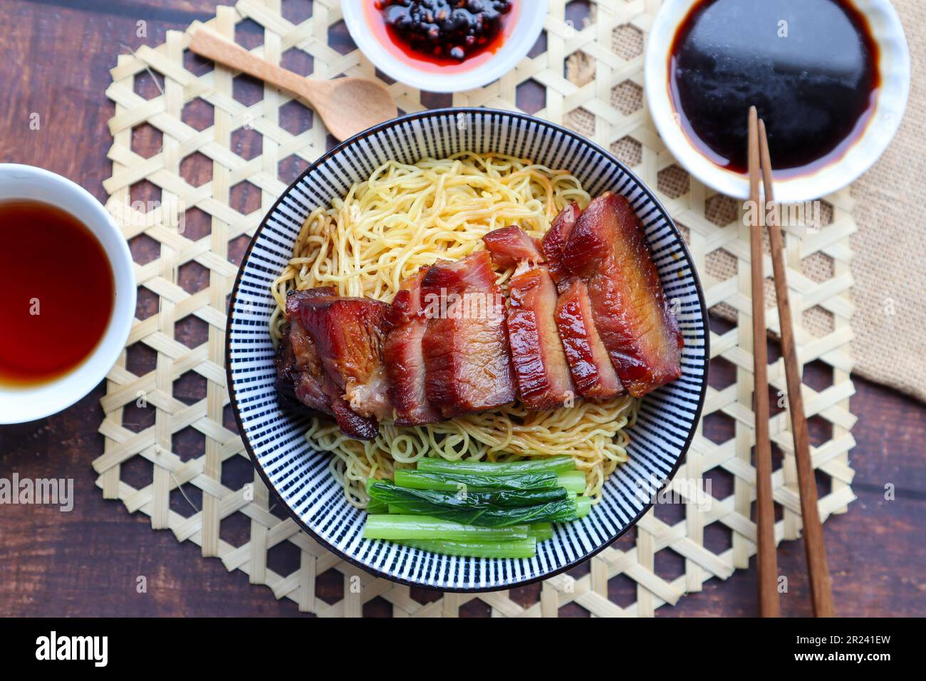Chinese barbecue roast pork noodle (Char Siu) in a bowl on bamboo ...