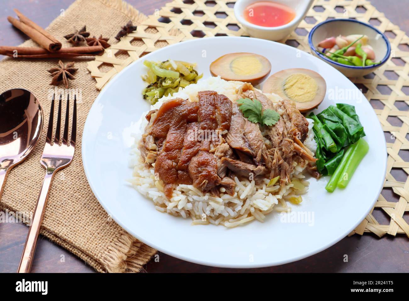 Stewed Pork leg and egg over rice at close up view on wood table ...