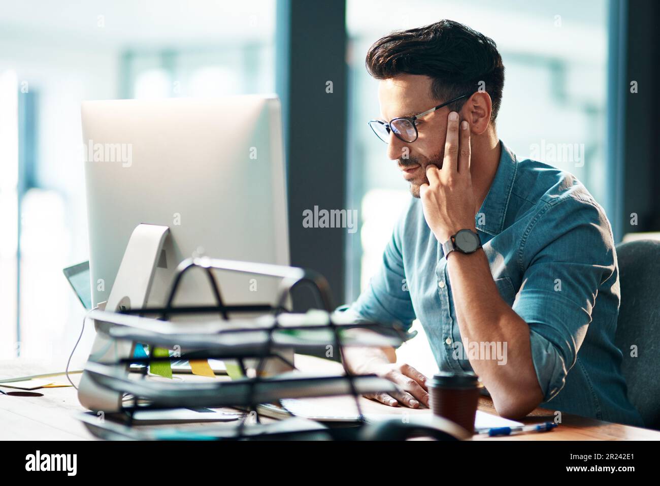 Serious, business man and computer in office for planning startup ...