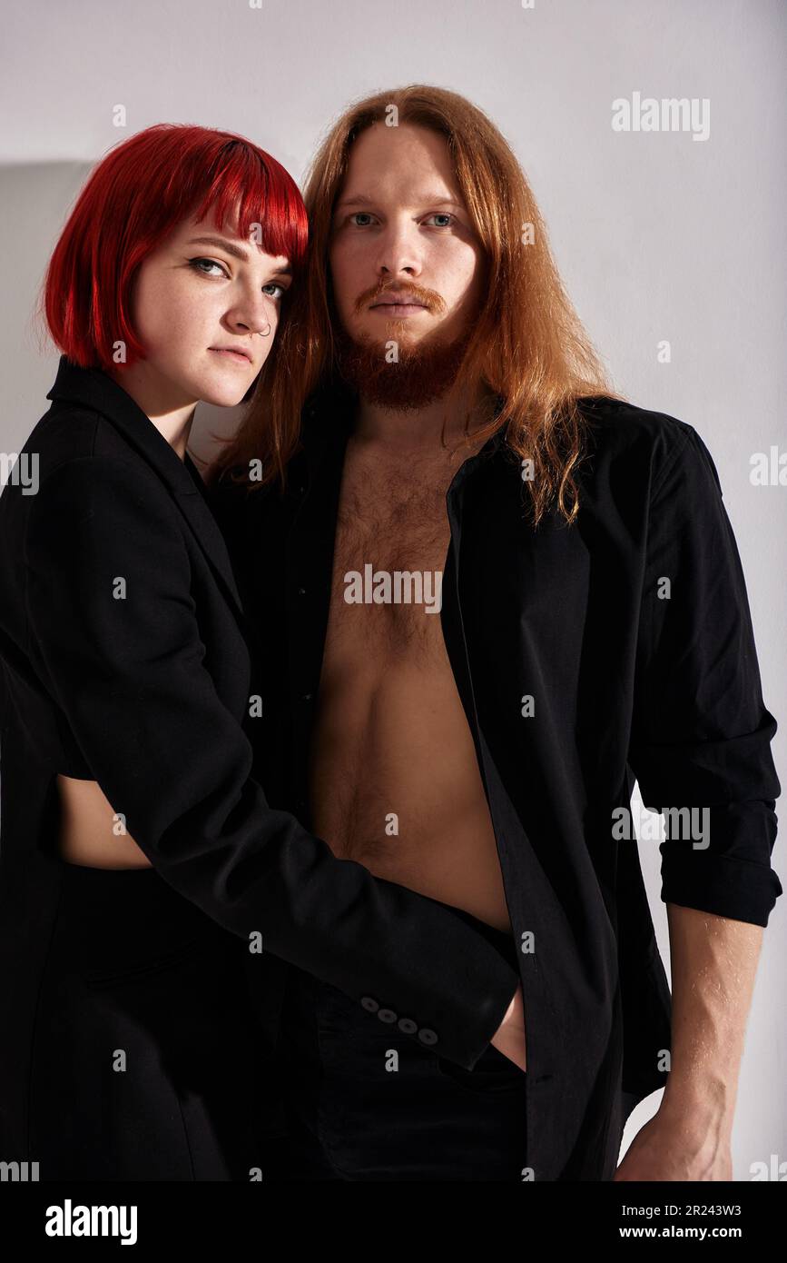 Studio portrait of a couple in love. A handsome man with long hair and ...
