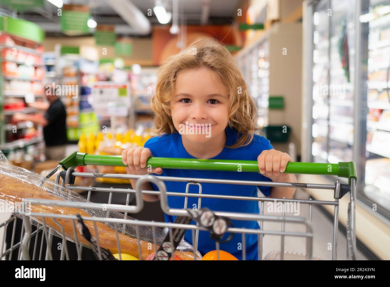 Kid with shopping cart at grocery store. Kid on shopping in supermarket ...
