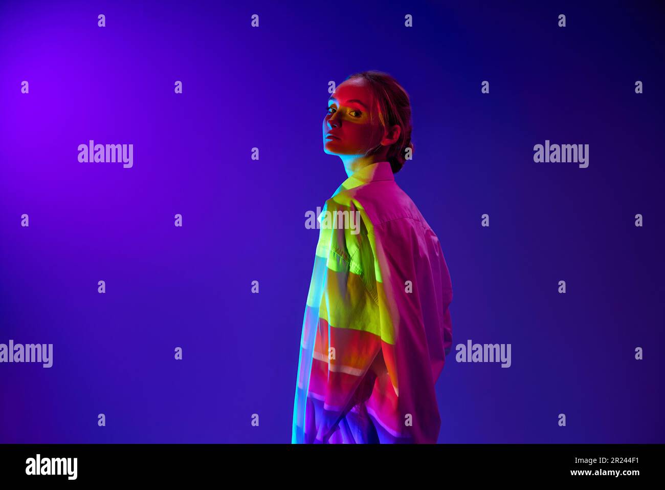 Portrait of young girl with multicolored neon filter reflection on body ...
