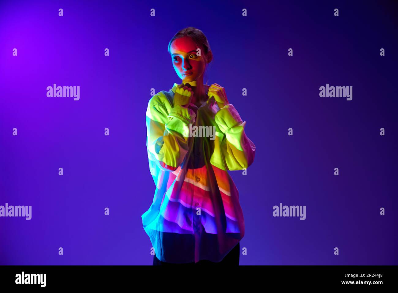 Portrait of beautiful, young girl with multicolored neon filter ...