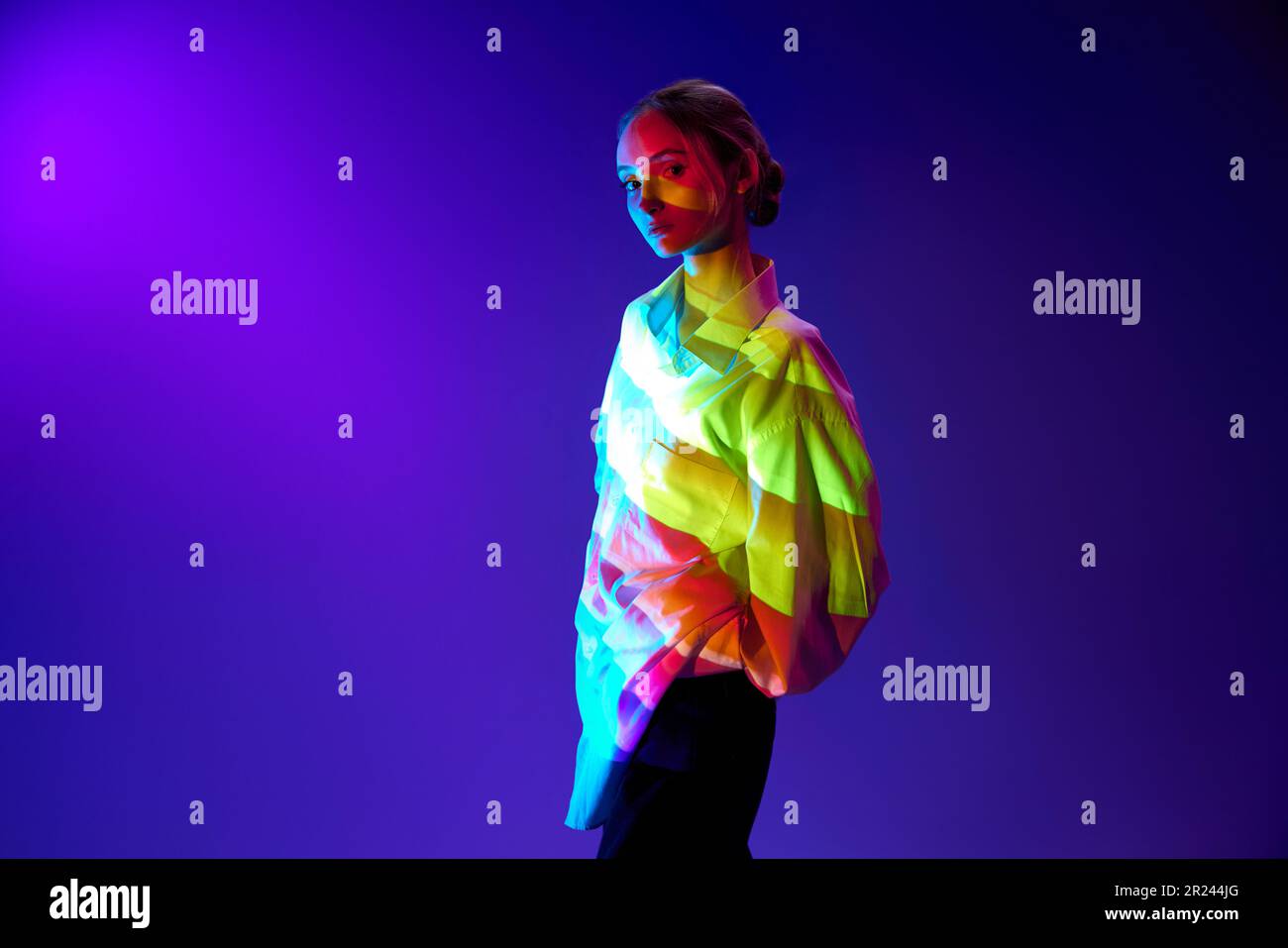 Portrait of beautiful, young girl with multicolored neon filter ...