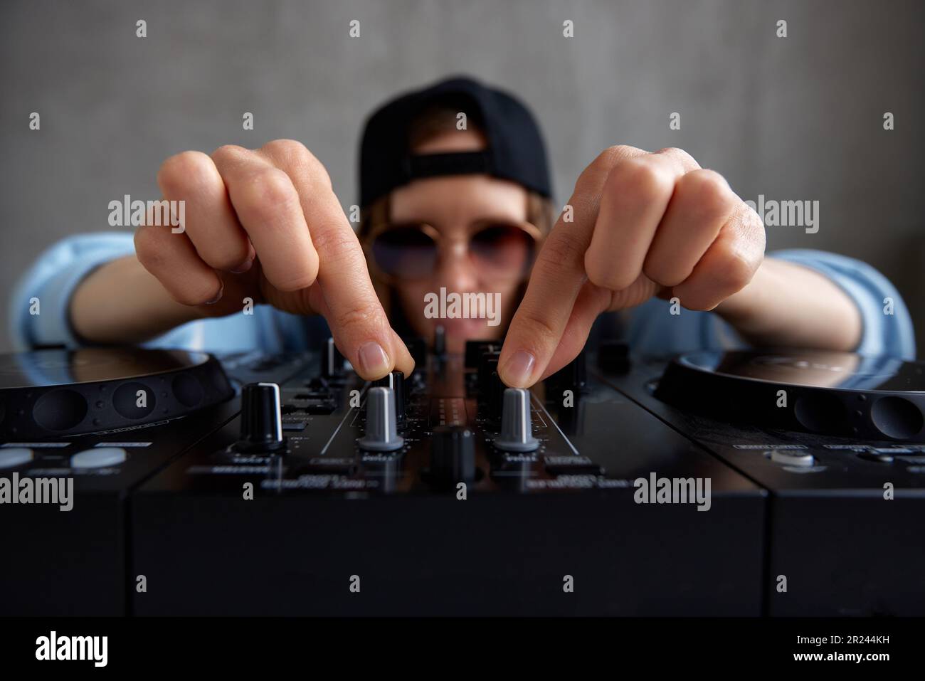 A young pretty long-haired DJ girl in a blue sweater and a black ...