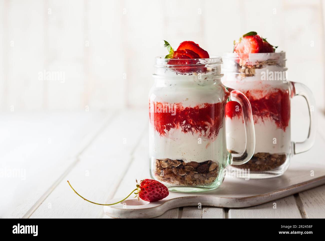 Healthy breakfast in a Mason jar with yogurt, strawberry puree and ...