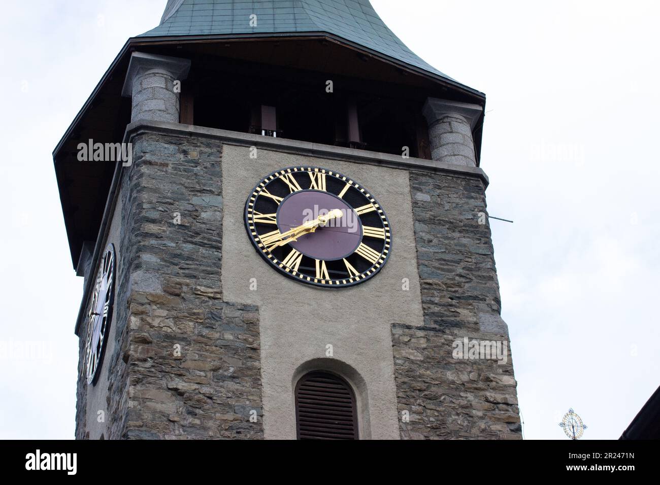 Misty sky embraces iconic clock tower in Zermatt village, a blend of ...