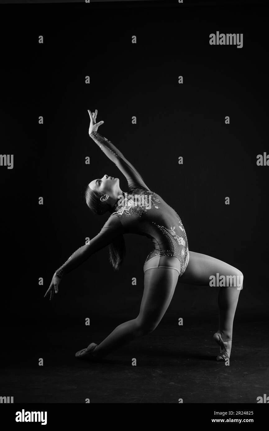 Flexible Girl Rhythmic Gymnastics Artist Jumping On White Dark Background Grace In Motion