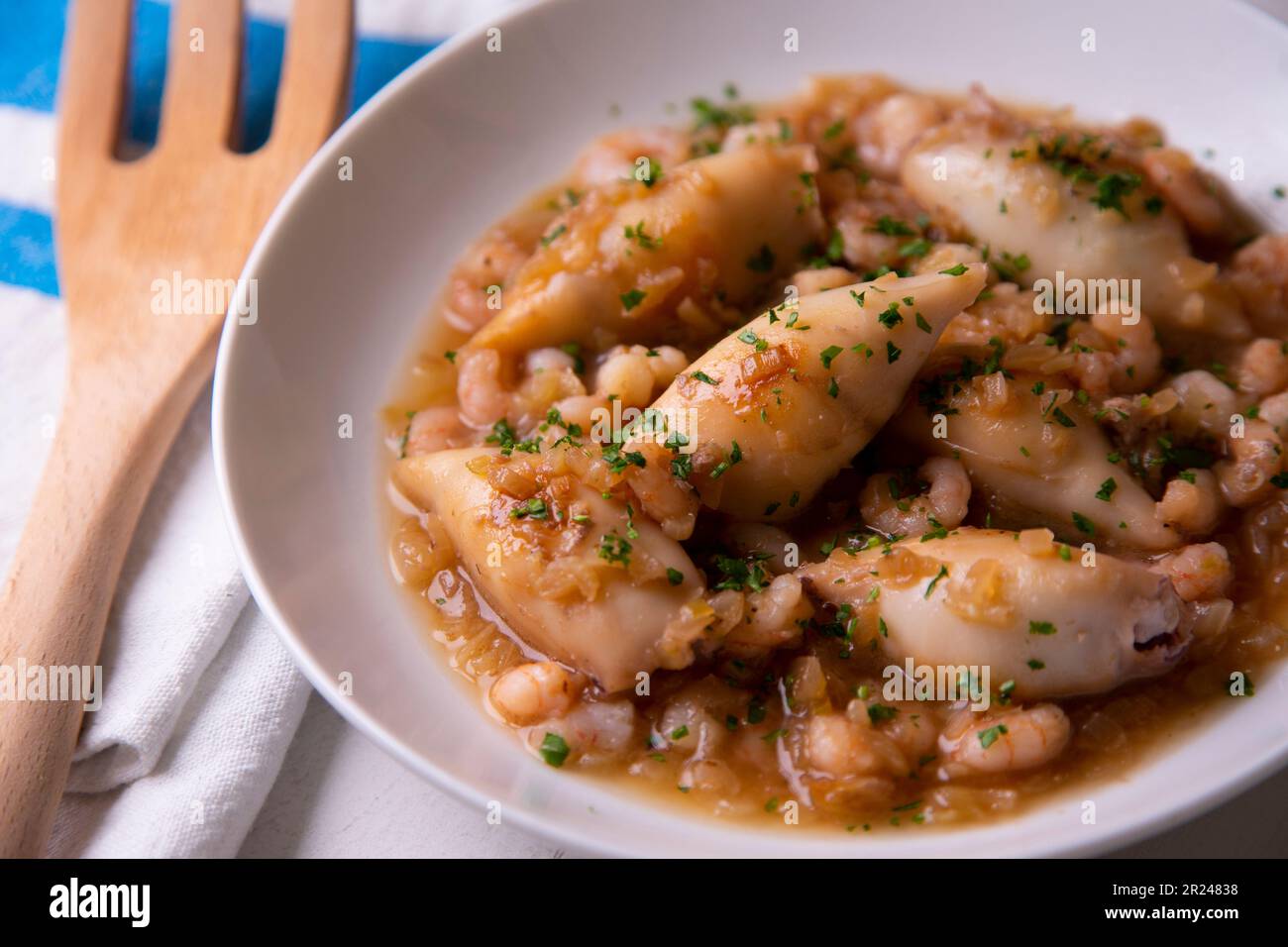 Baby Squid stew with potatoes and prawns. Traditional Spanish recipe ...