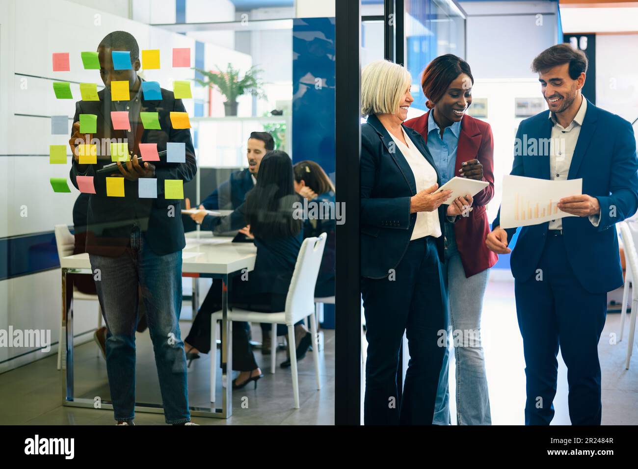 Group of positive multiracial colleagues in formal wear discussing ...