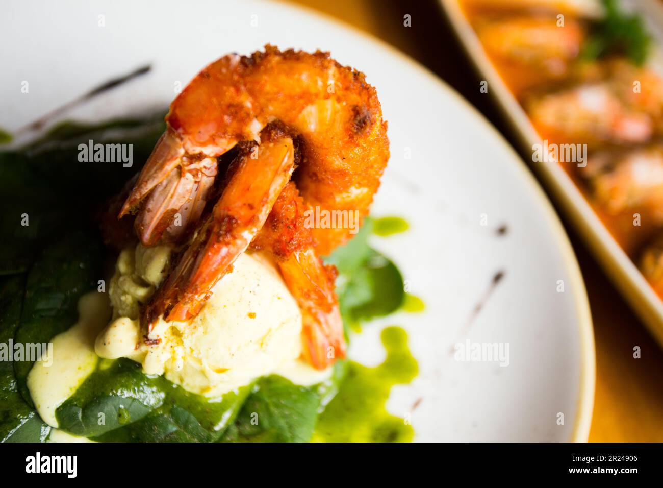 Breaded prawns with coconut ice cream on spinach Stock Photo - Alamy