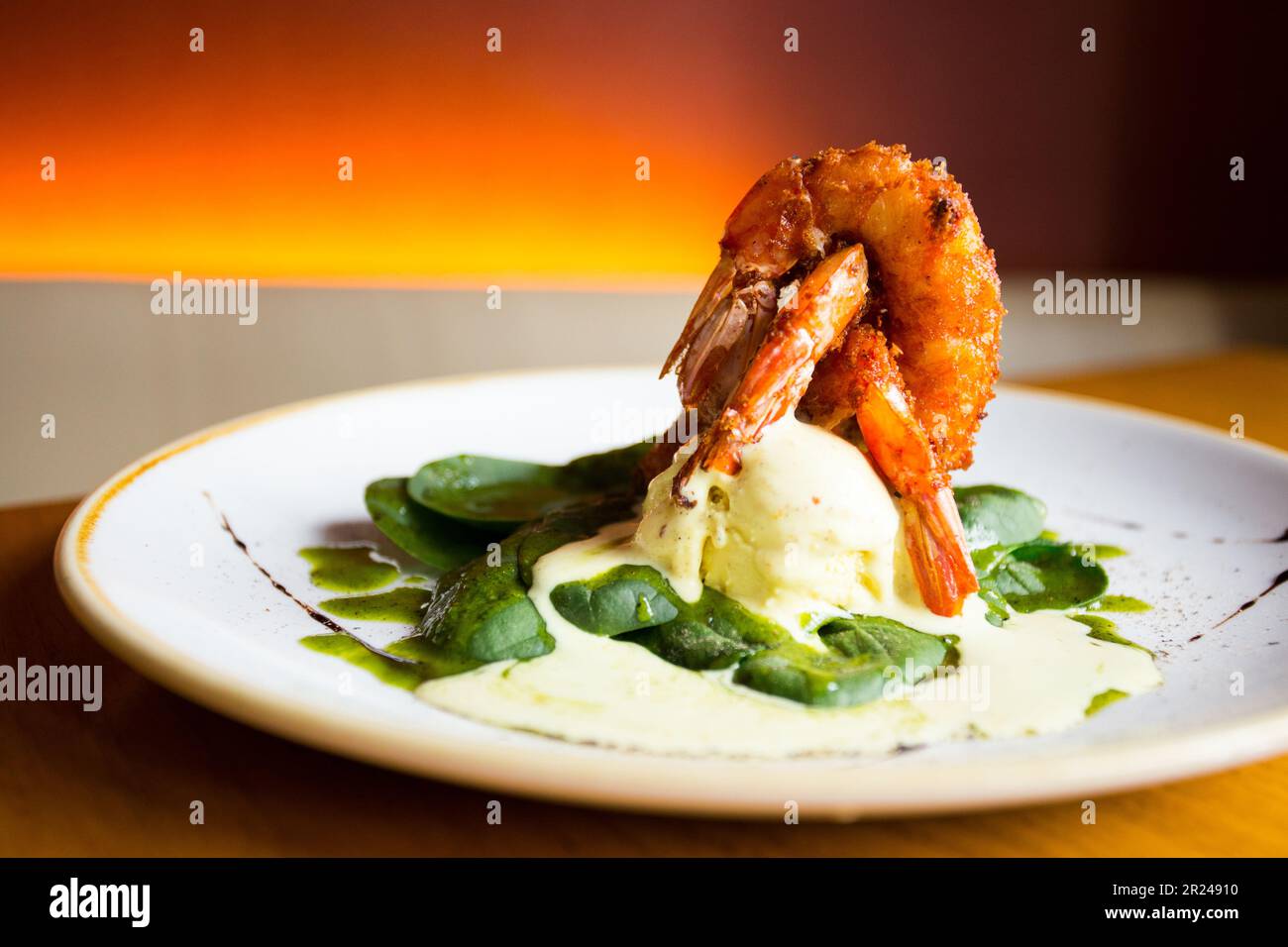 Breaded prawns with coconut ice cream on spinach Stock Photo - Alamy
