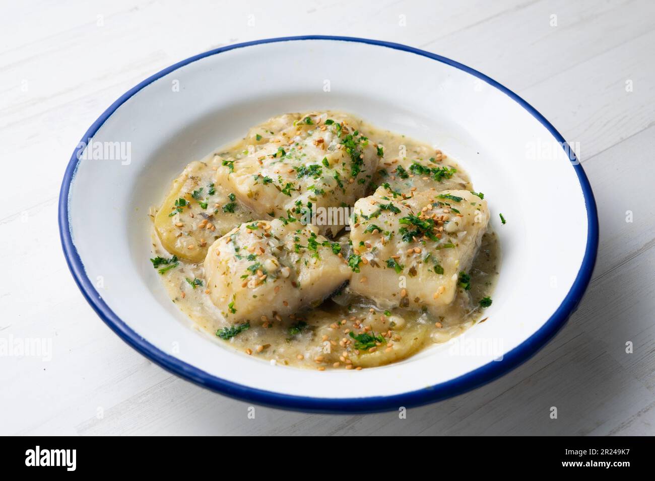 Hake cooked with green parsley and garlic sauce served with clams ...