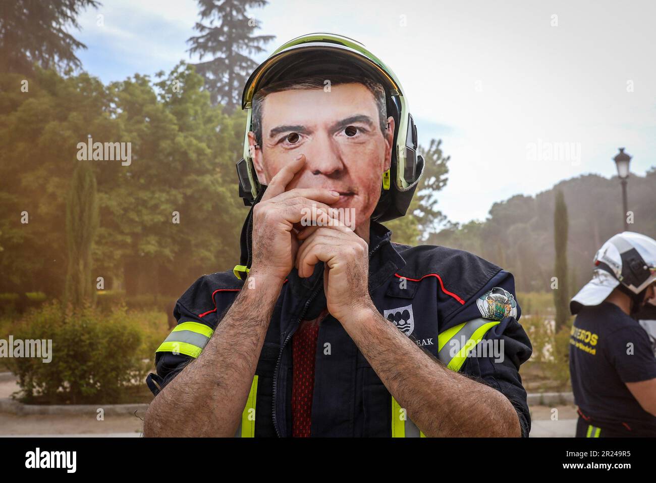 Madrid, Spain. 16th May, 2023. A firefighter marches with a mask of the ...
