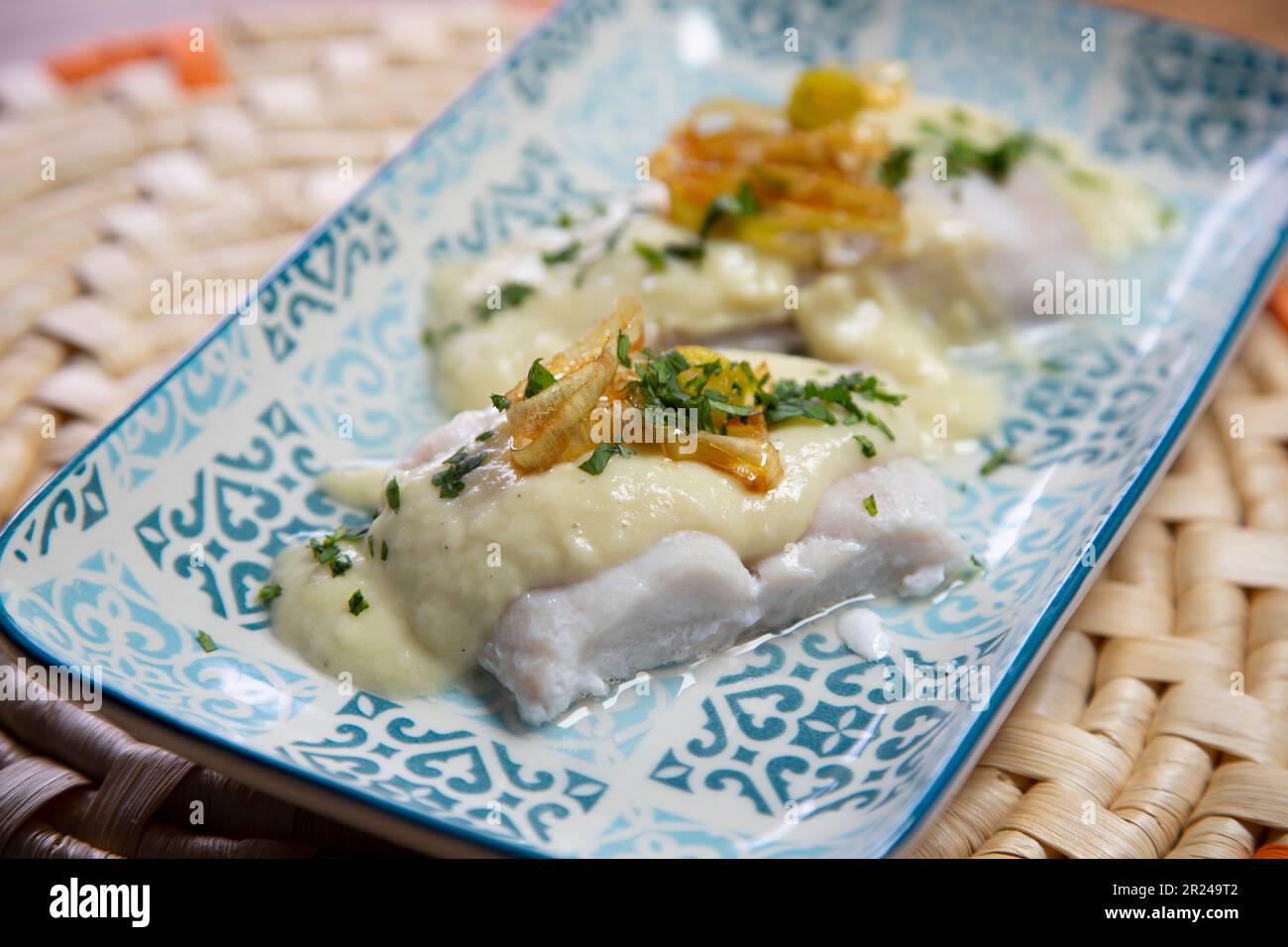 Baked hake fillet cooked with leek sauce. Traditional Spanish tapa ...