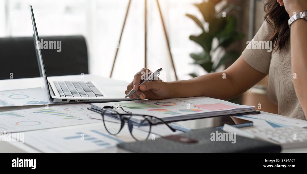 Closed up young business woman read write doing report figure paper ...