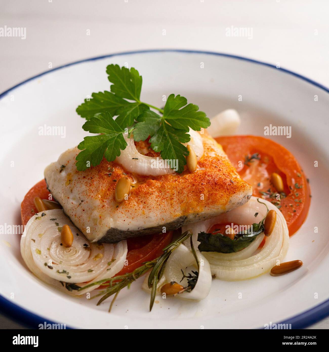 Baked hake fillet cooked with tomato and onion. Traditional Spanish ...