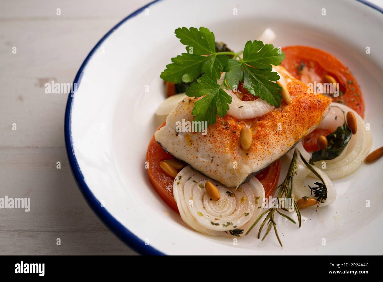 Baked hake fillet cooked with tomato and onion. Traditional Spanish ...
