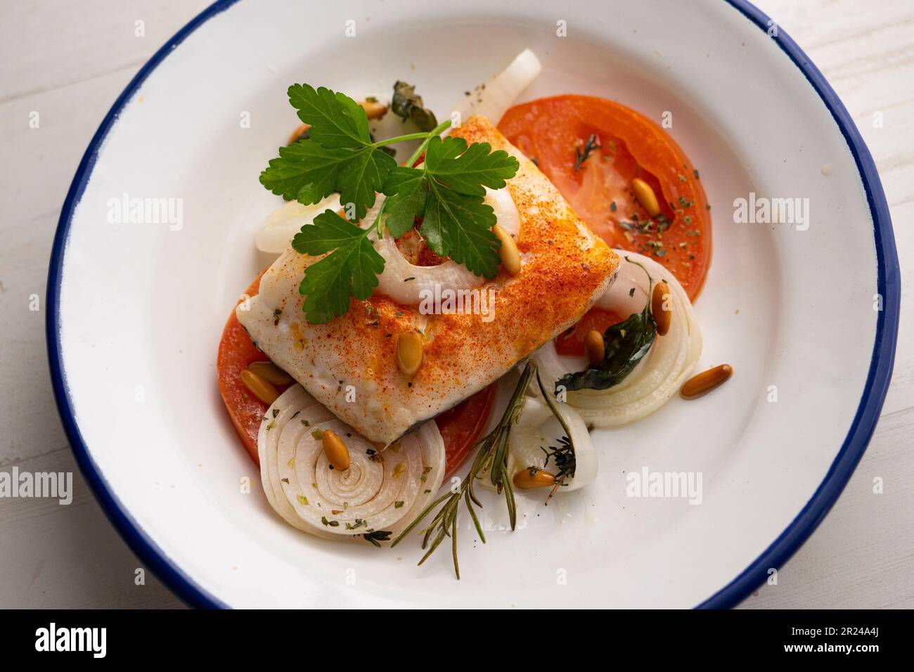 Baked hake fillet cooked with tomato and onion. Traditional Spanish ...