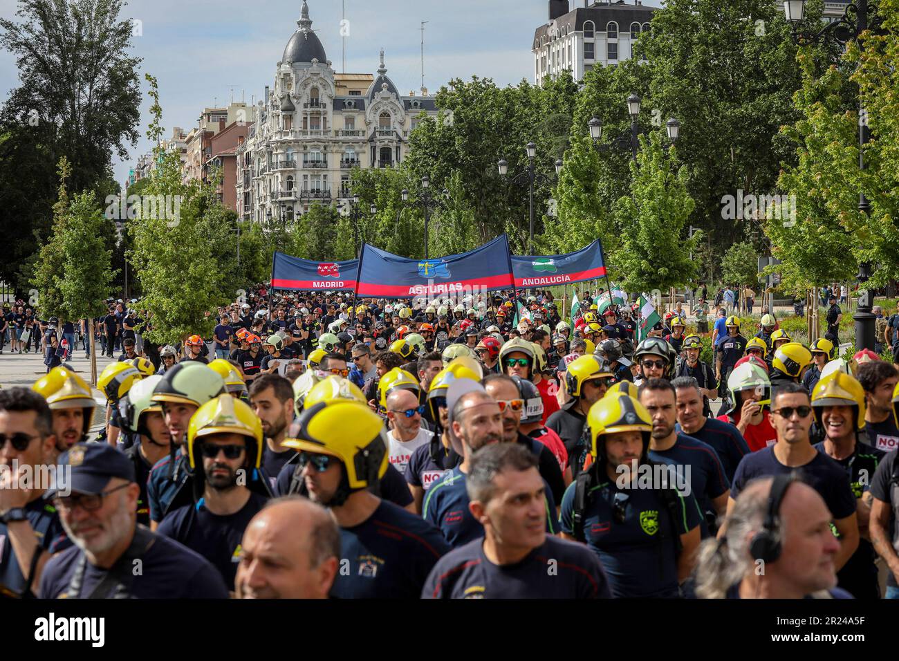 A group of firefighters march through the Plaza de España carrying ...