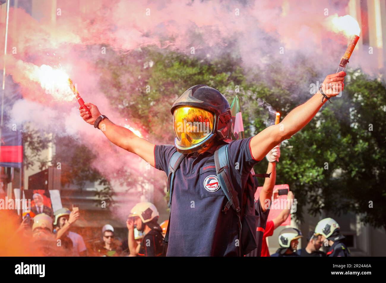 A firefighter carries a fire flare as he marches through the San ...