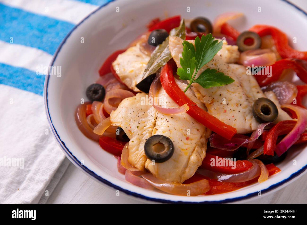 White fish filet cooked with black olives and red peppers Stock Photo ...