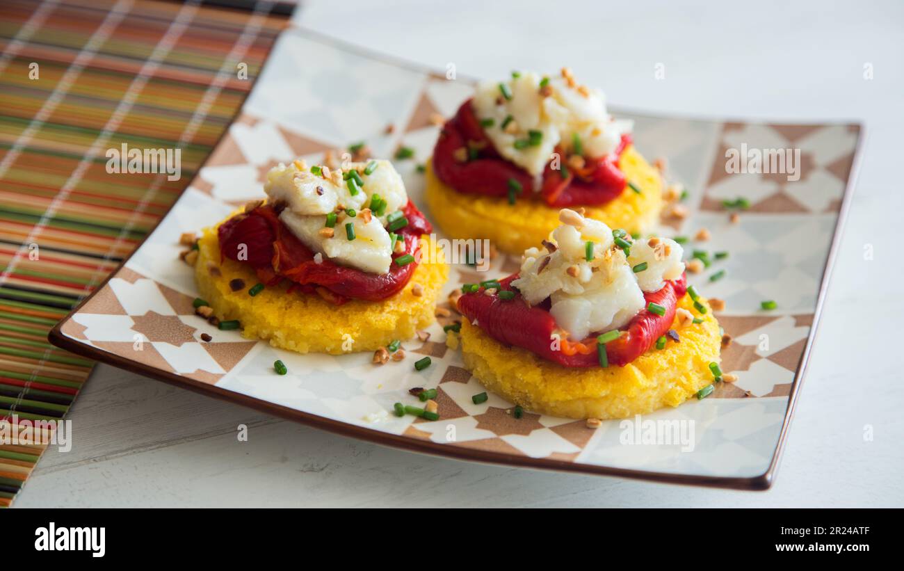 Polenta toast with red pepper and cod Stock Photo - Alamy