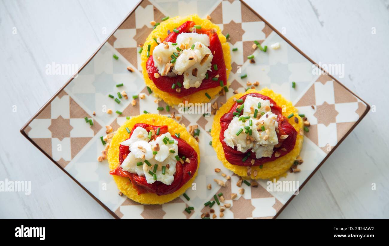 Polenta toast with red pepper and cod Stock Photo - Alamy
