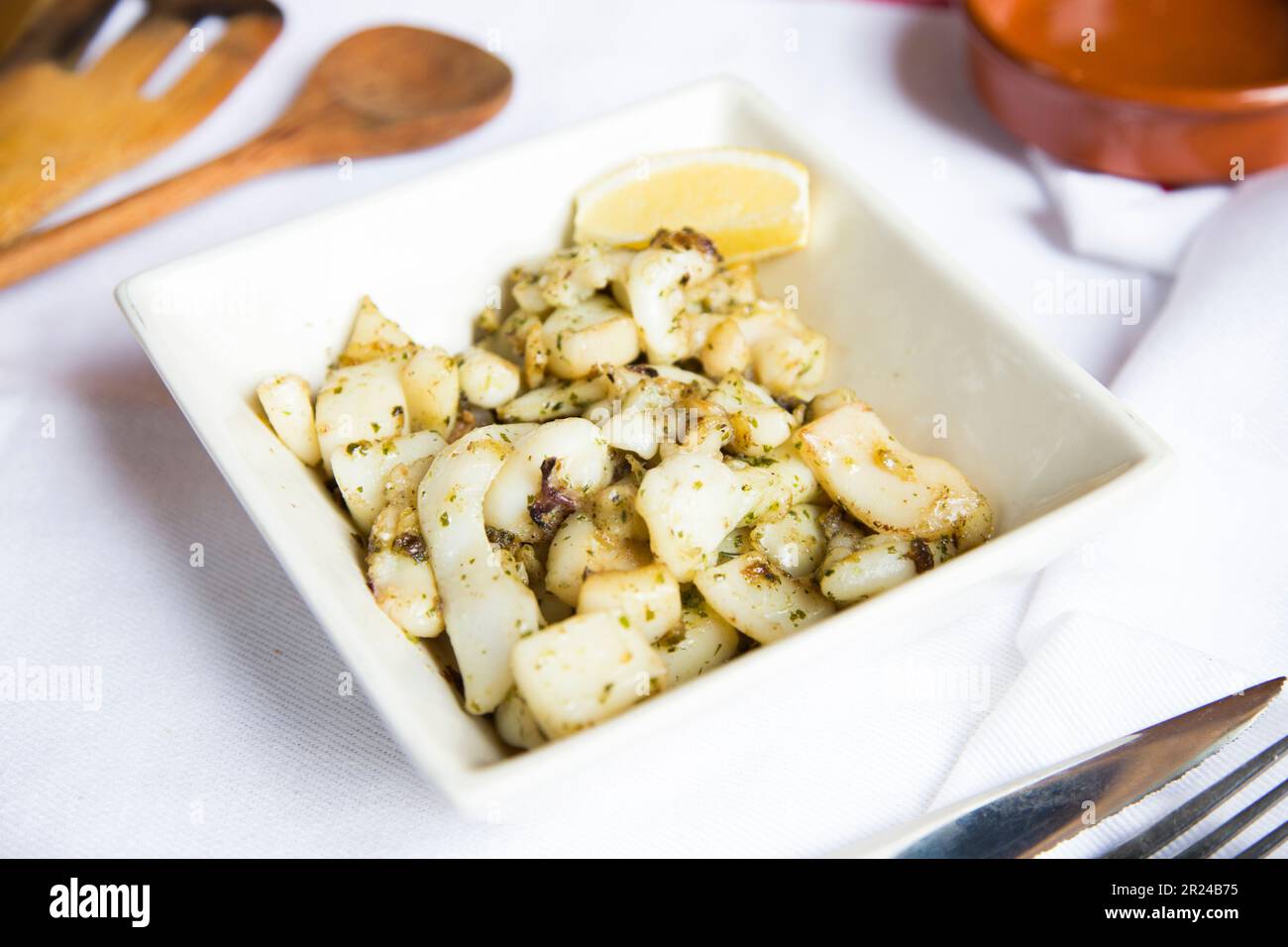 Rabas al ajillo. Rabas cooked with garlic. Squid leg tapa served with ...