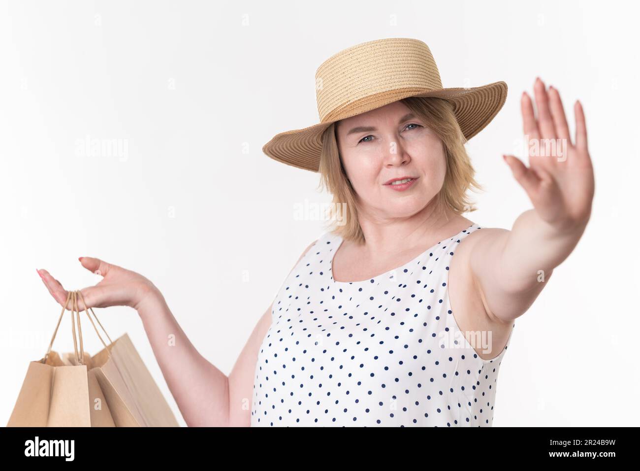Woman shopper in white dress with black polka dots and straw hat put ...