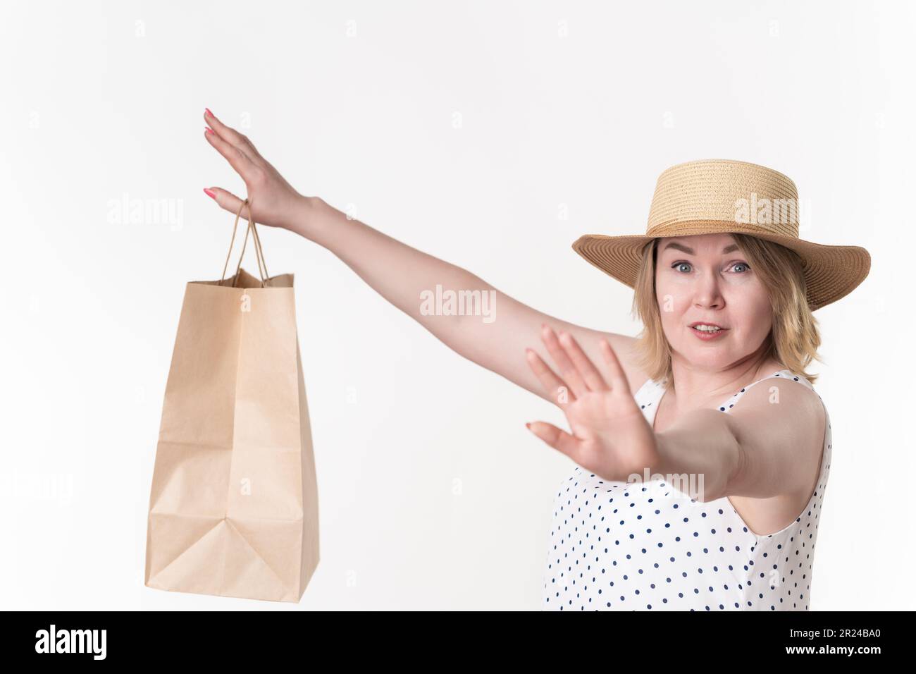 Serious woman shopper holds paper craft bag for shopping in her hand ...