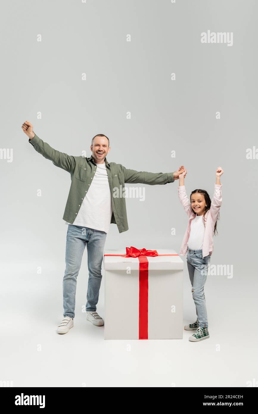 Full length of excited and carefree father and preteen daughter looking ...