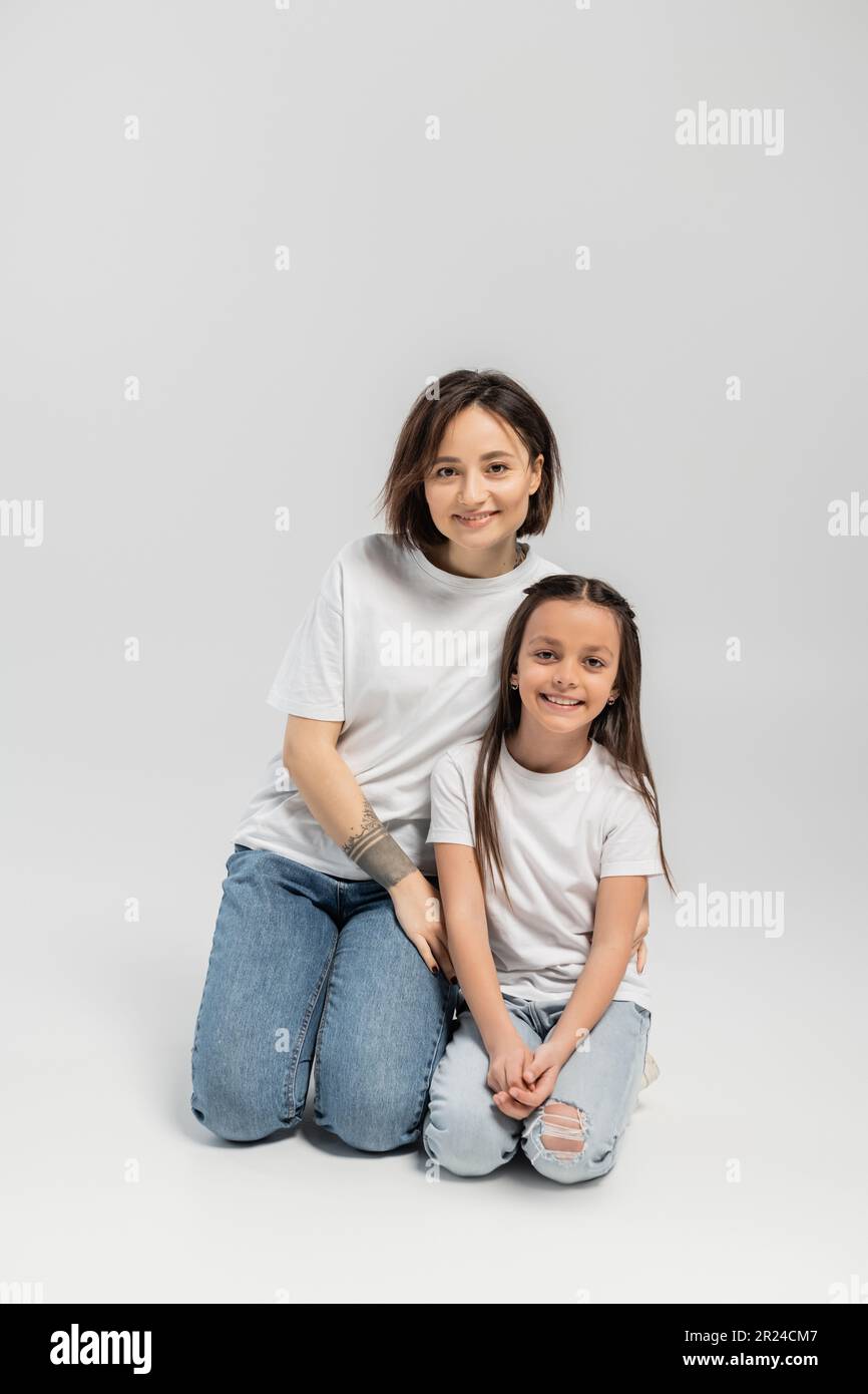 Happy Mother With Tattoo On Hand And Short Hair Hugging Preteen